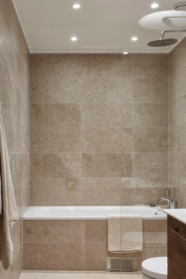 Badrumsinspiration med kalkstensliknande granitkeramik